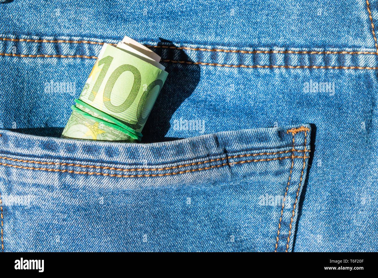 Roll of euro banknotes in a pocket Stock Photo - Alamy