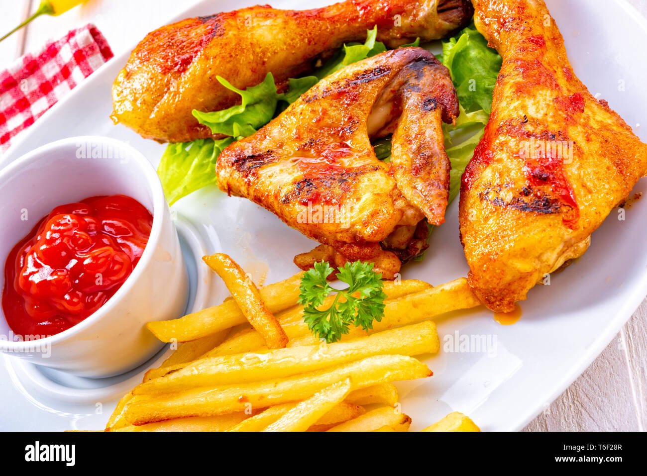 Grilled chicken wings,legs,chips and vegetables Stock Photo - Alamy