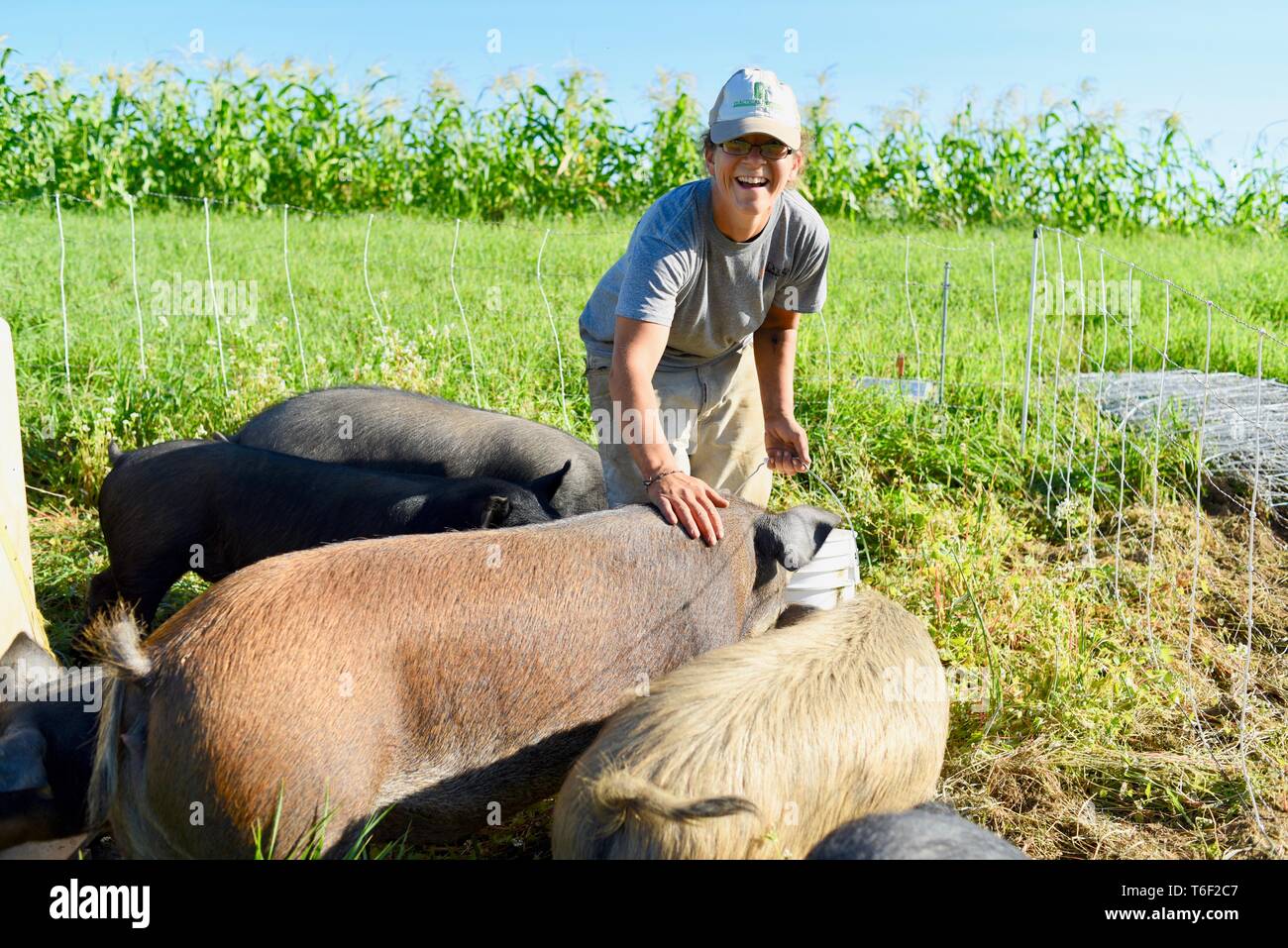Hard working woman farmer on small farm doing chores of bringing water ...