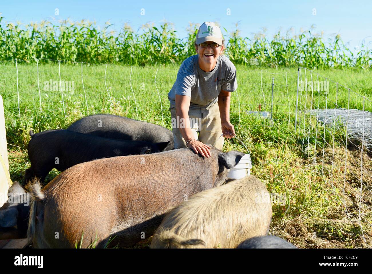 Hard working woman farmer on small farm doing chores of bringing water ...