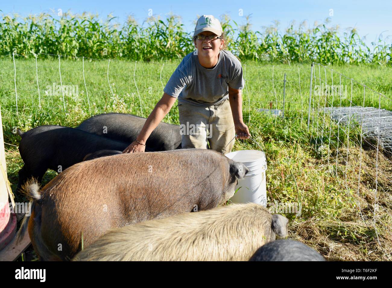 Hard working woman farmer on small farm doing chores of bringing water ...