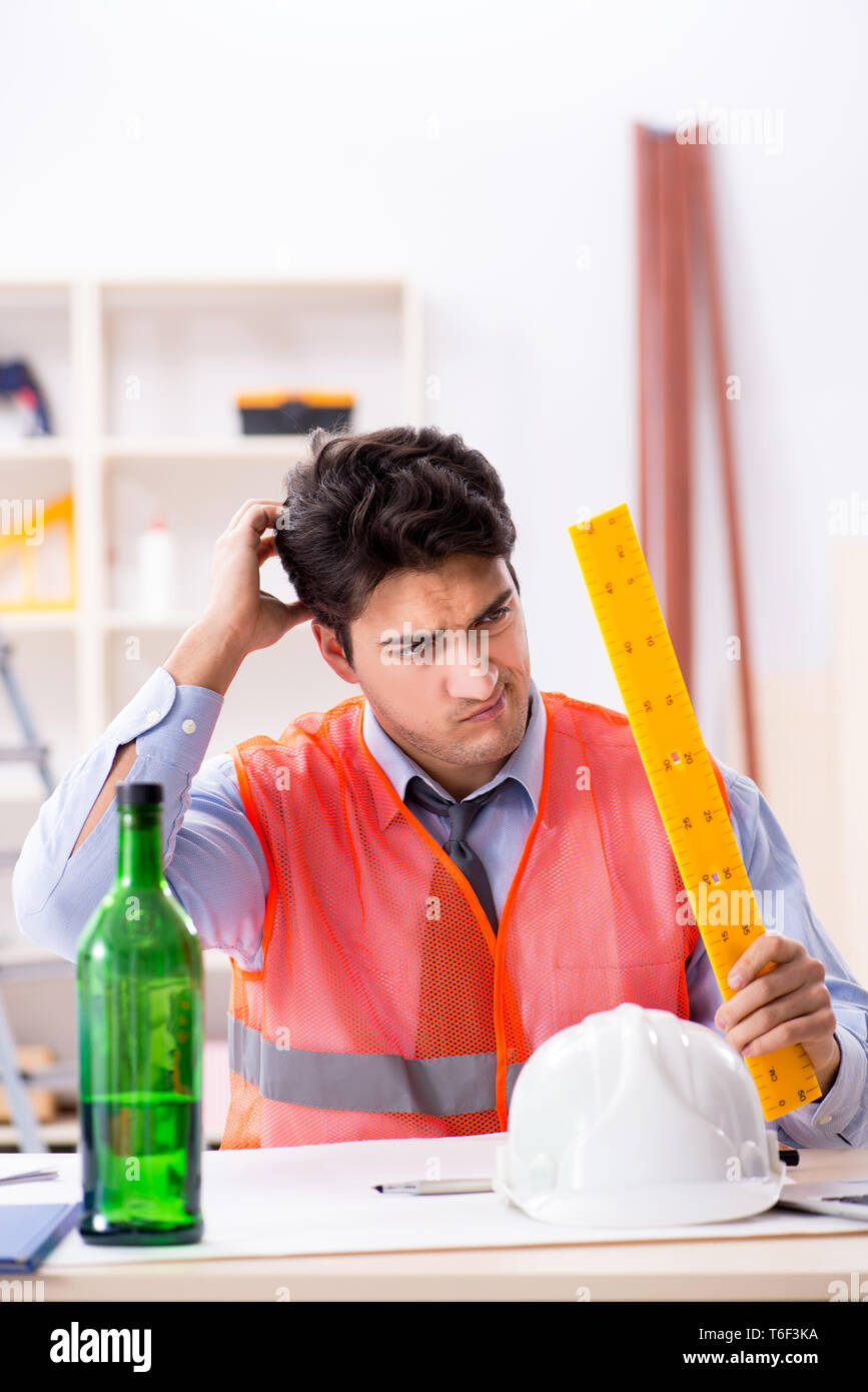 Drunk engineer working in the workshop Stock Photo - Alamy