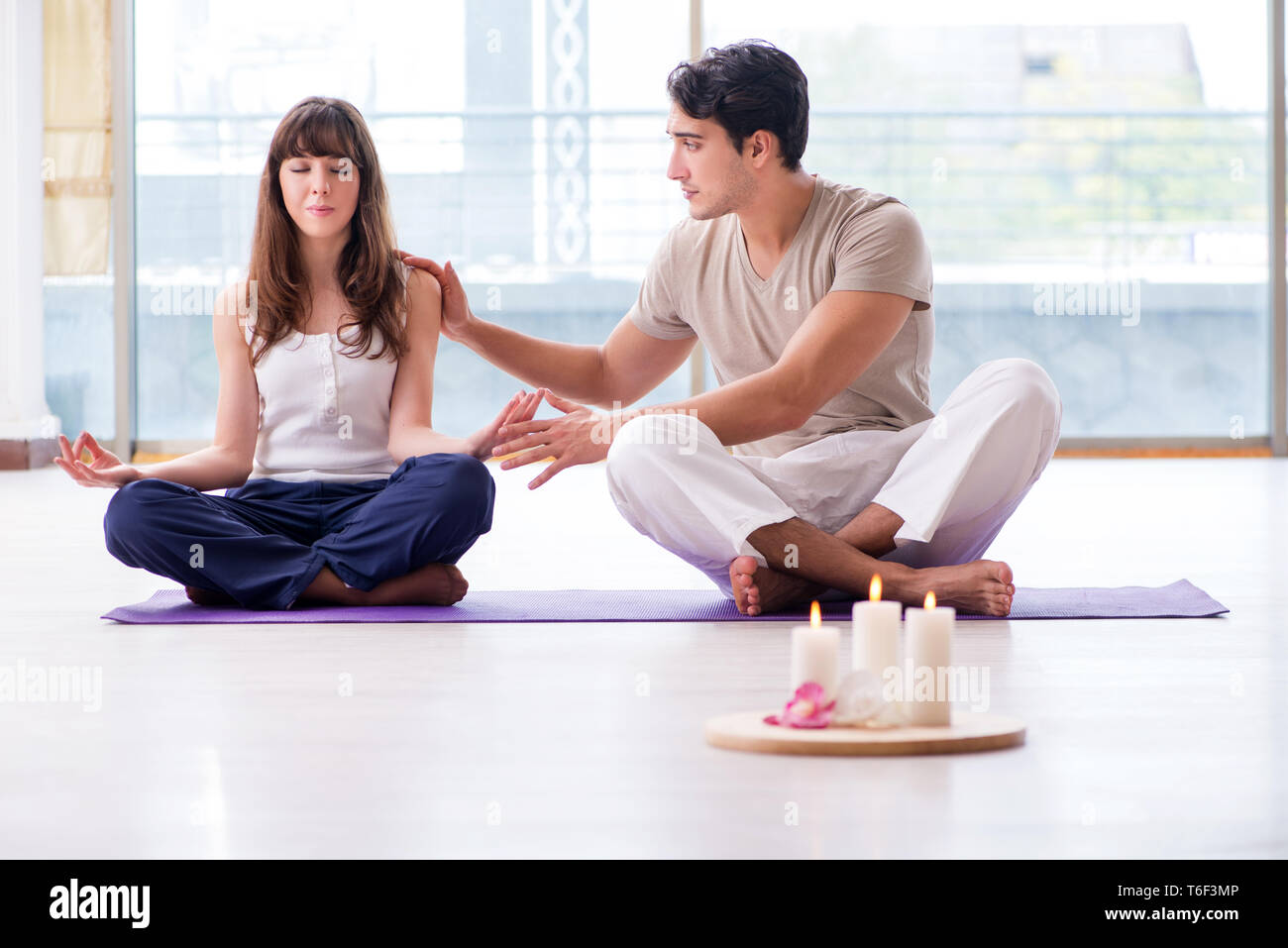 Personal coach helping during yoga session Stock Photo - Alamy
