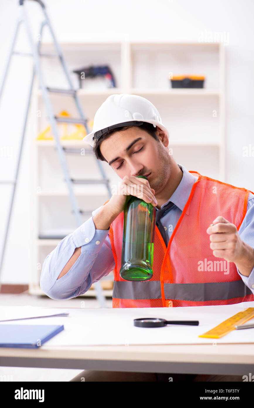 Drunk engineer working in the workshop Stock Photo - Alamy