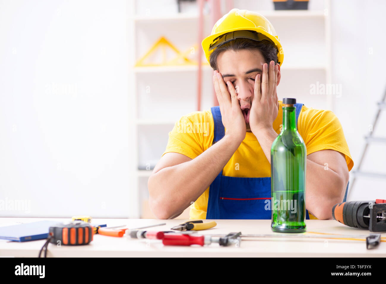 Drunk engineer working in the workshop Stock Photo - Alamy