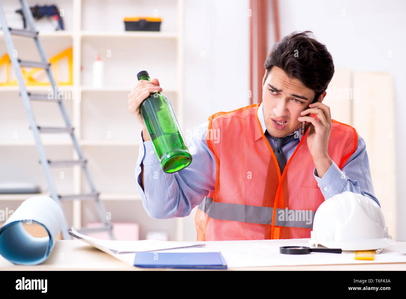 Drunk engineer working in the workshop Stock Photo - Alamy