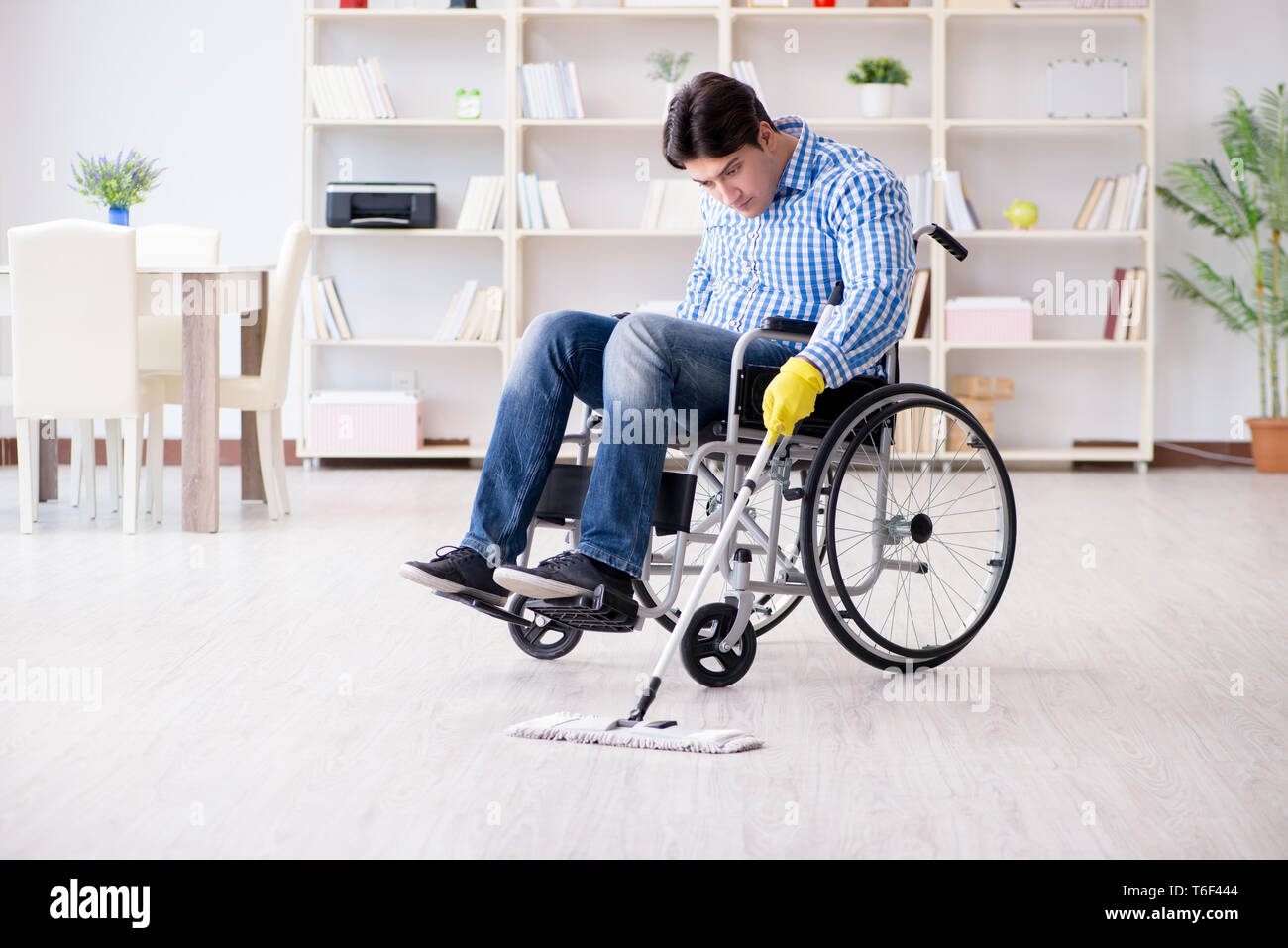 Disabled man on wheelchair cleaning home Stock Photo - Alamy