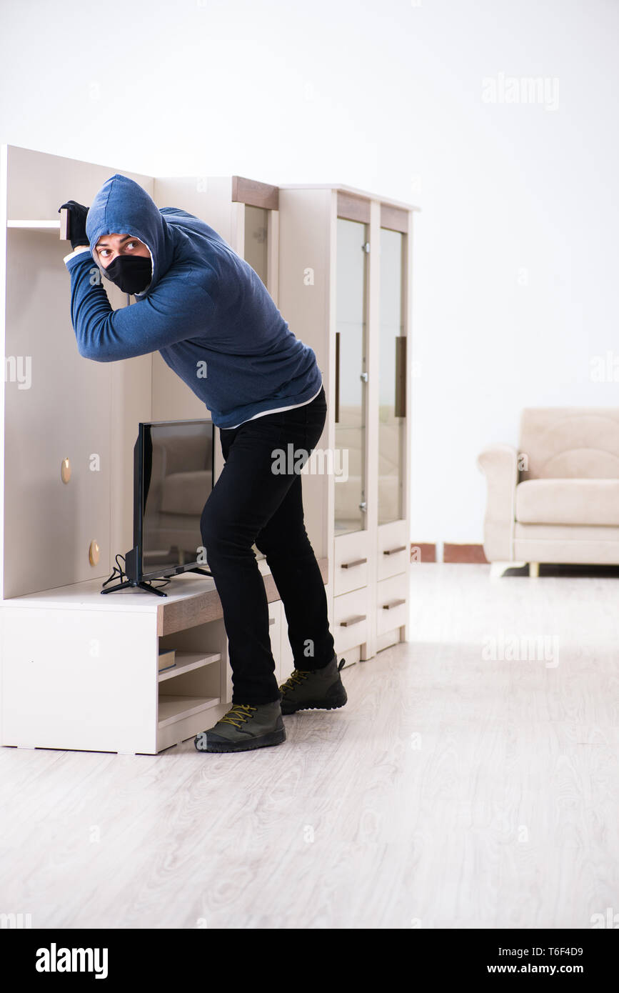 Man burglar stealing tv set from house Stock Photo - Alamy