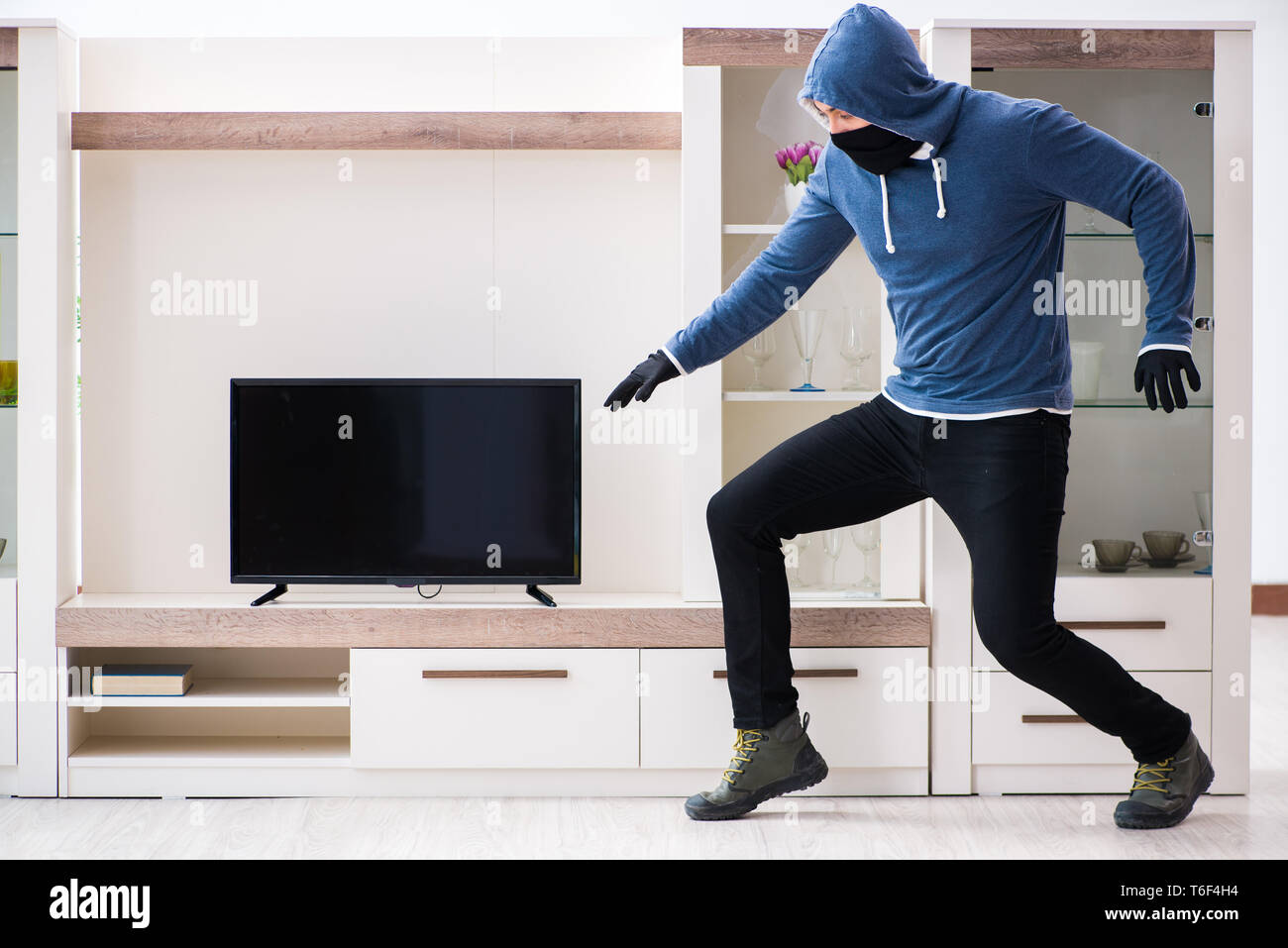 Man burglar stealing tv set from house Stock Photo - Alamy