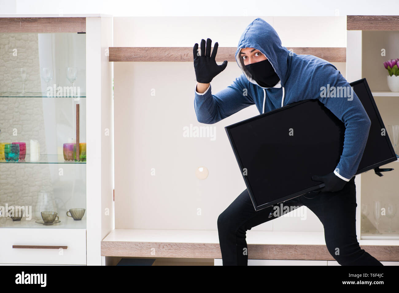 Man burglar stealing tv set from house Stock Photo - Alamy