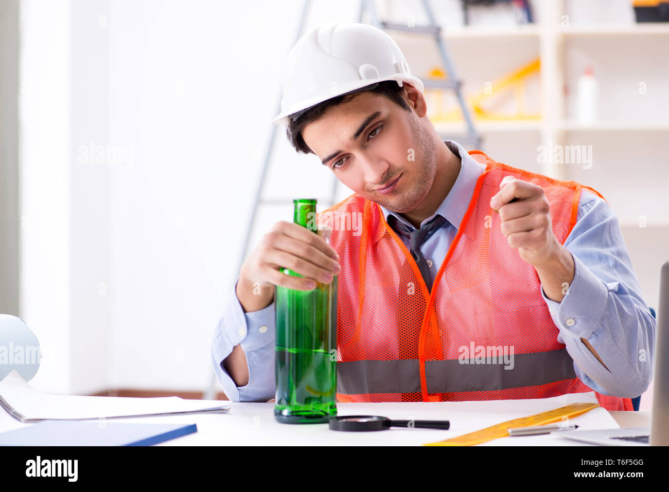 Drunk engineer working in the workshop Stock Photo - Alamy
