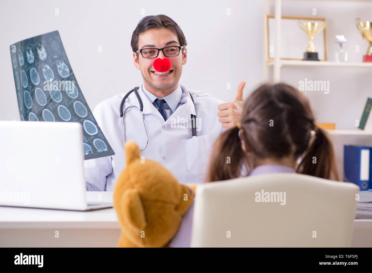 Funny pediatrician with little girl at regular check-up Stock Photo - Alamy