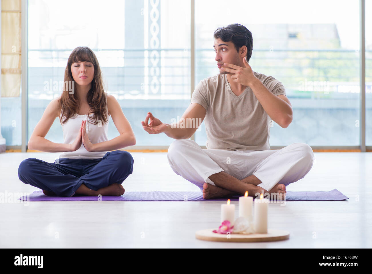 Personal coach helping during yoga session Stock Photo - Alamy
