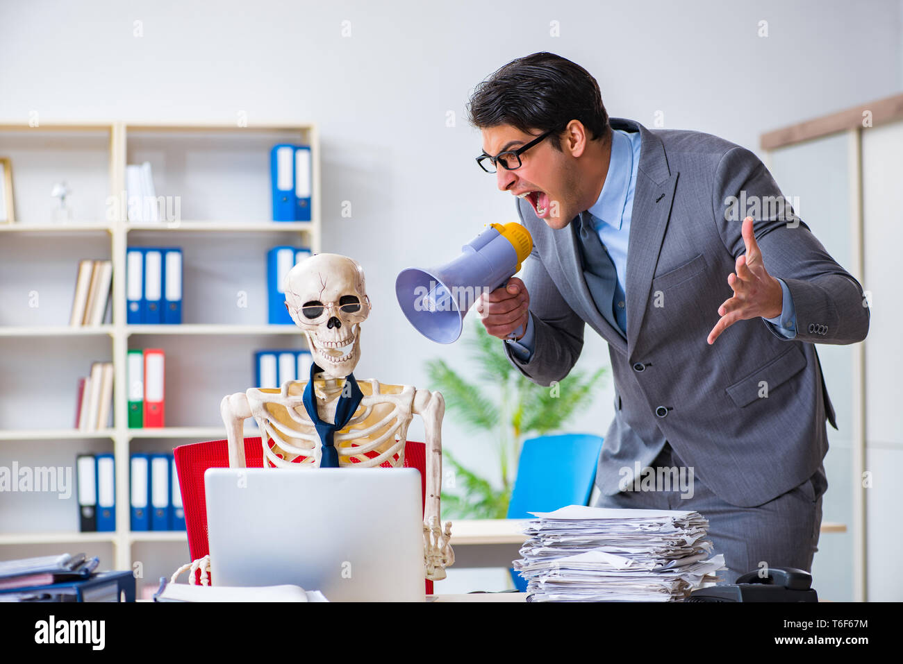 Angry boss yelling at his skeleton employee Stock Photo - Alamy