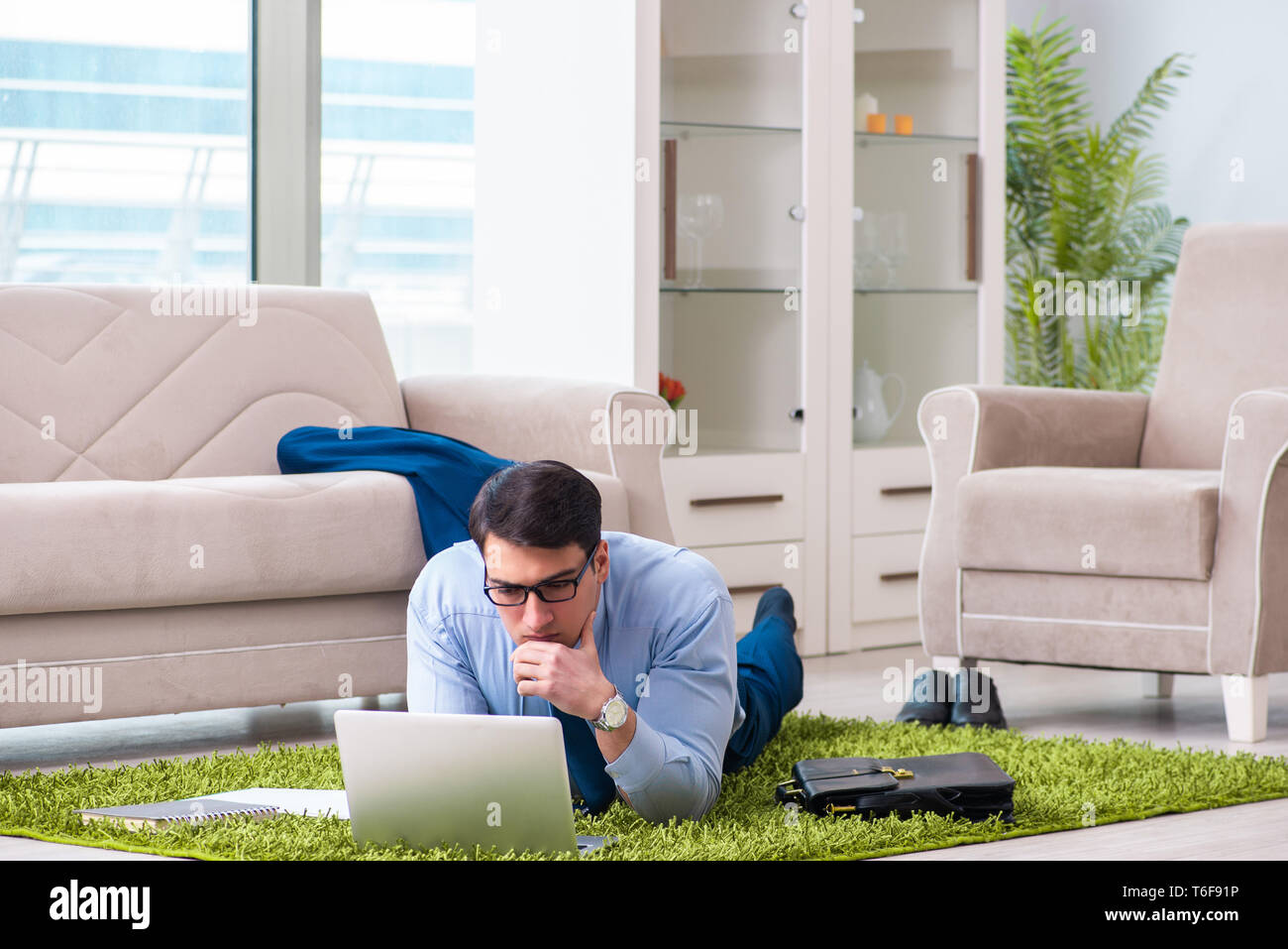 Businessman taking work home and working overtime Stock Photo - Alamy