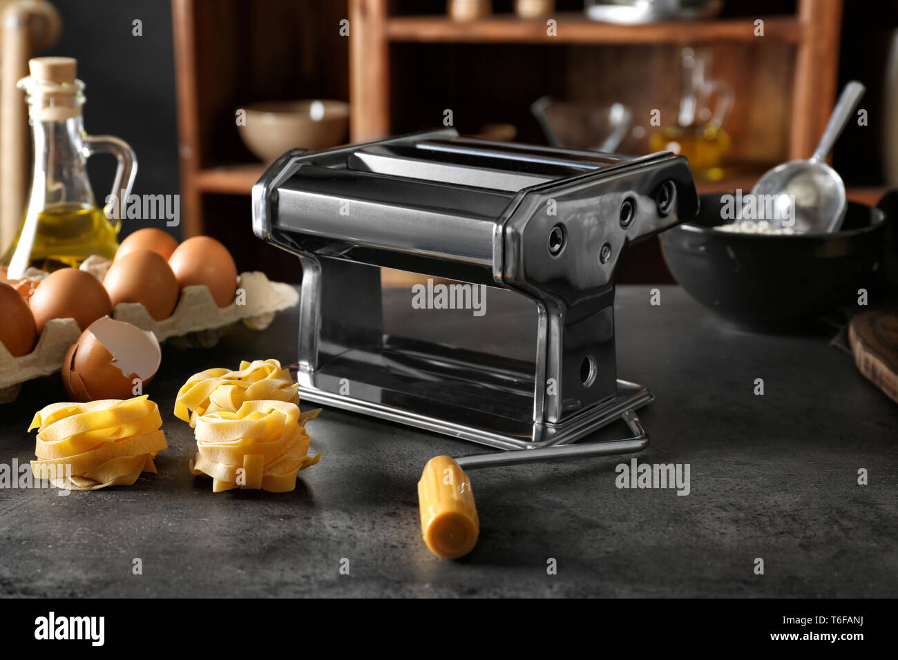 Metal pasta maker and products on kitchen table Stock Photo - Alamy