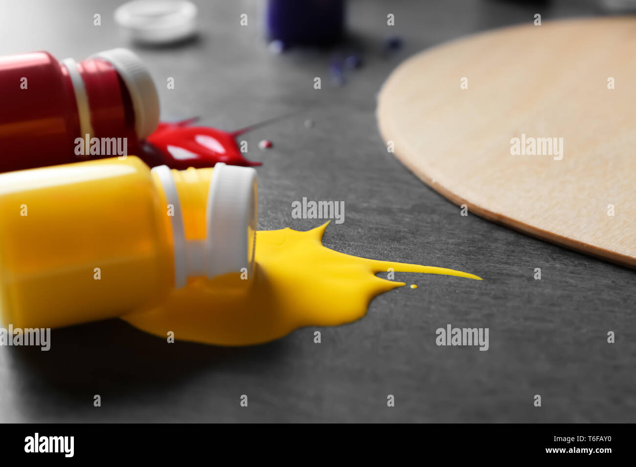 Overturned bottle with spilled paint on table Stock Photo - Alamy