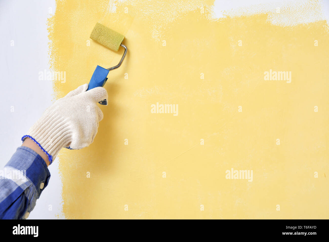 Painter using roller brush indoors Stock Photo - Alamy