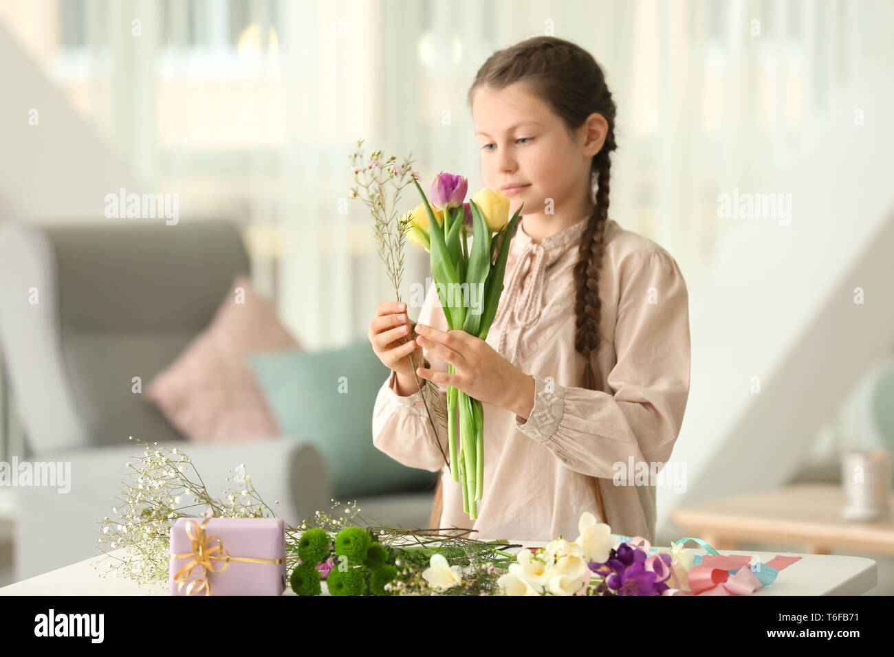 Little girl preparing bouquet of flowers for mother at home Stock Photo ...