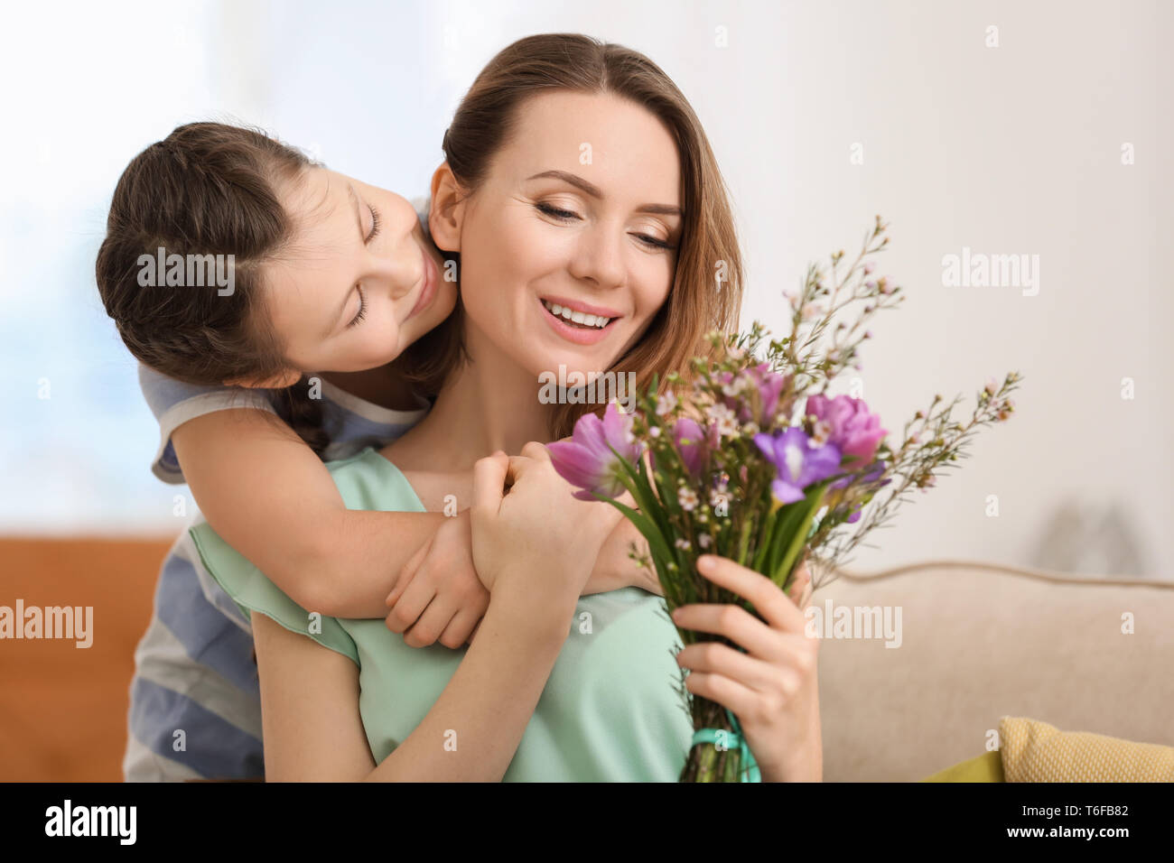Cute little girl greeting mother at home Stock Photo - Alamy