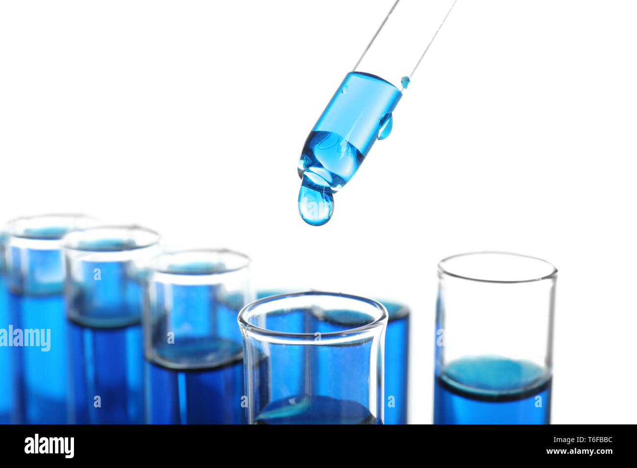 Dripping blue liquid into test tubes on white background Stock Photo ...
