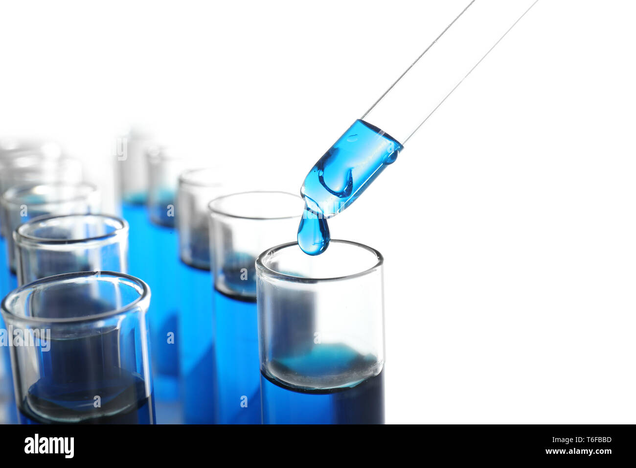 Dripping blue liquid into test tubes on white background Stock Photo ...
