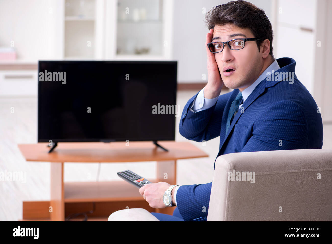 Businessman watching tv in the office Stock Photo - Alamy