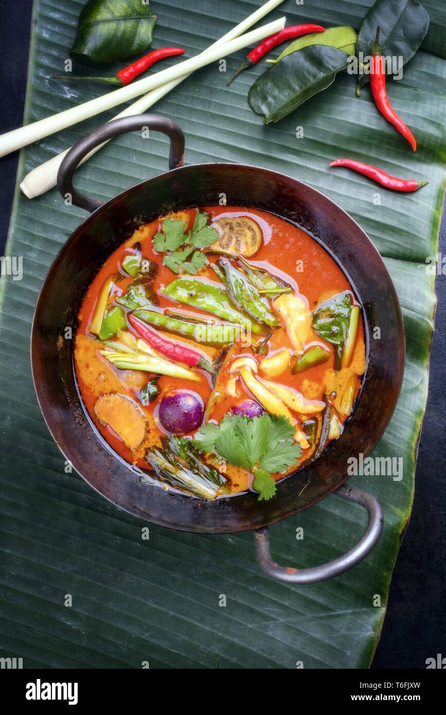 Traditional Thai kaeng phet red curry with vegetables as top view in a ...