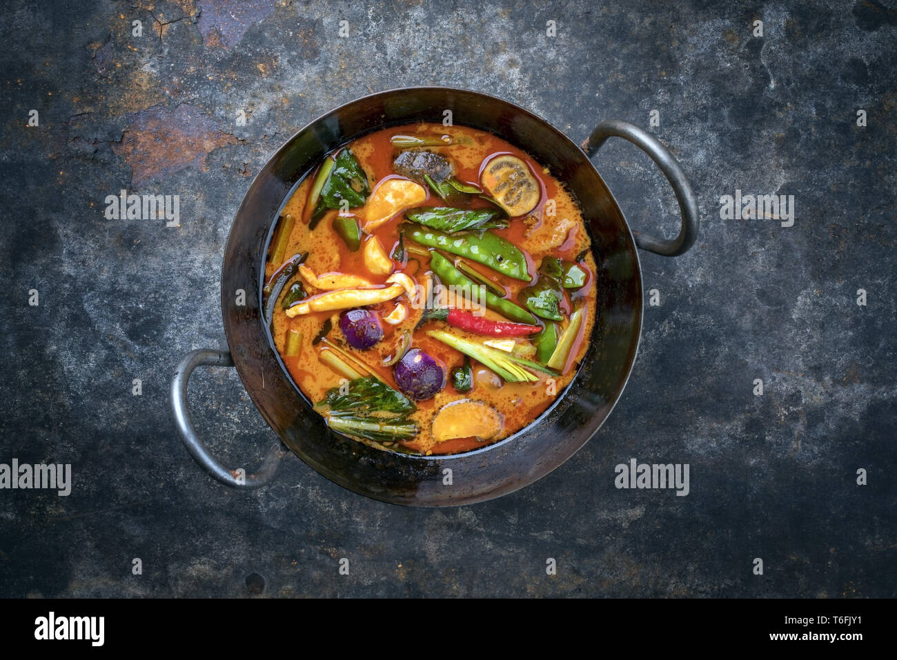 Traditional Thai kaeng phet red curry with vegetables as top view in a ...