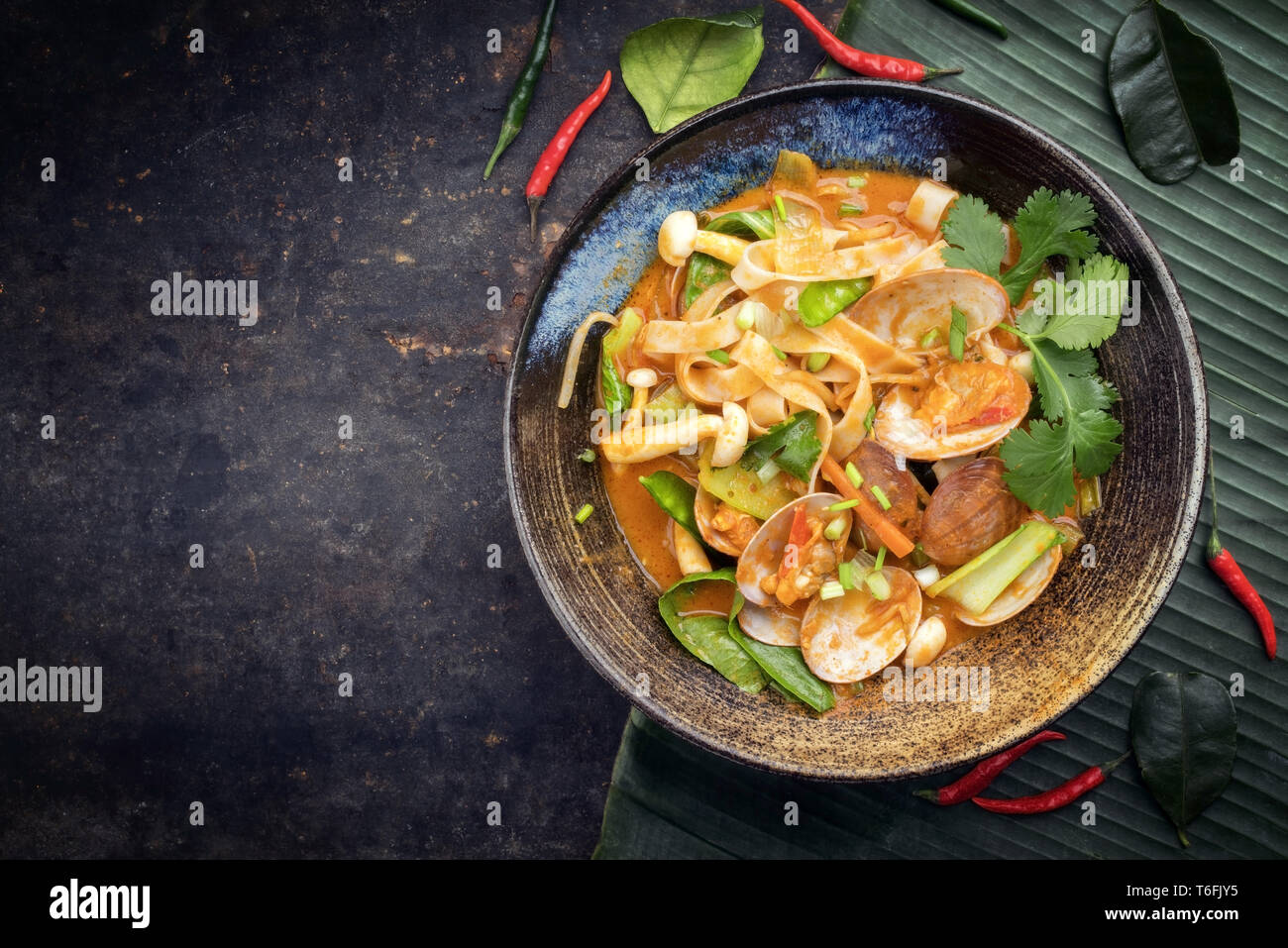 Traditional Thai kaeng phet red curry with clams and vegetable as top ...