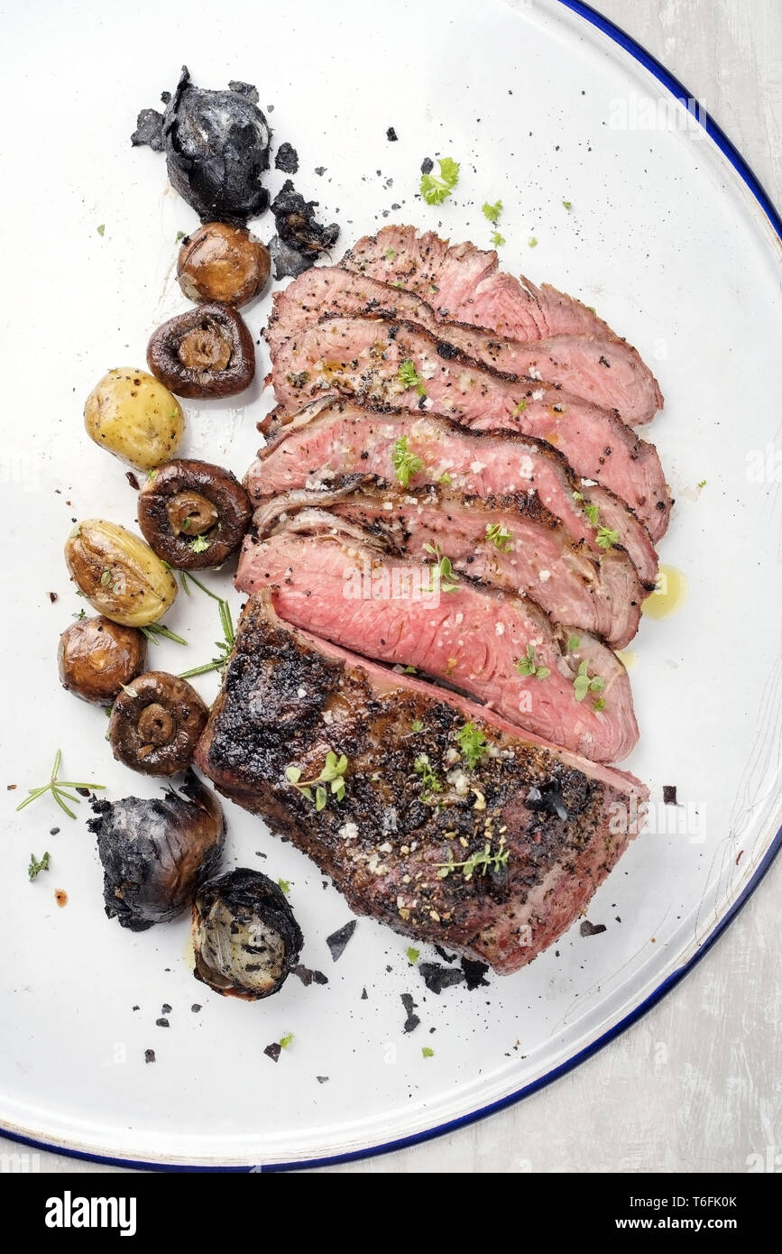 Barbecue caveman wagyu roast beef sliced with mushrooms and potatoes as ...