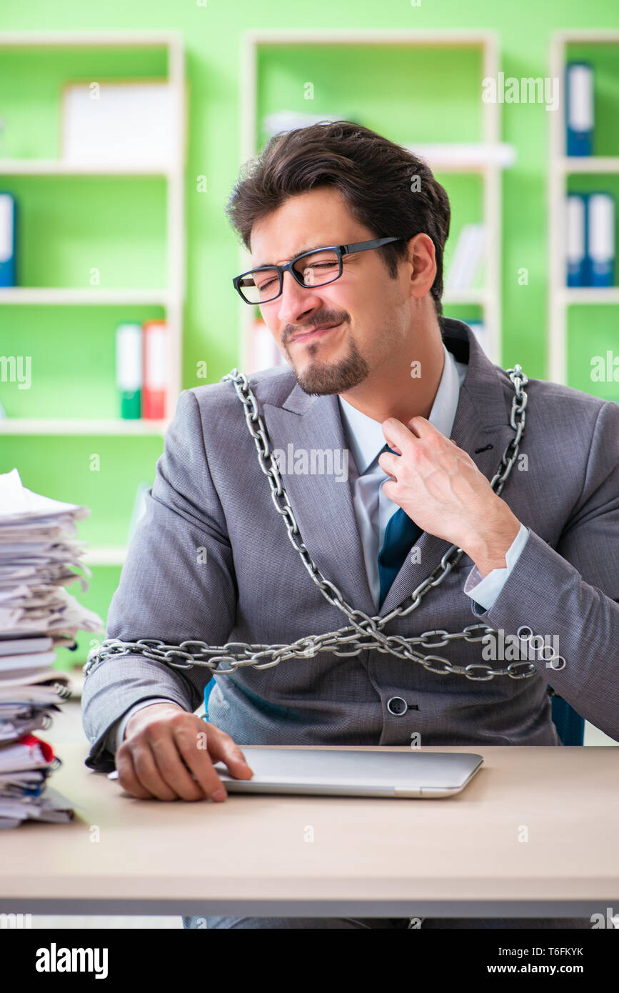 Employee chained to his desk due to workload Stock Photo - Alamy