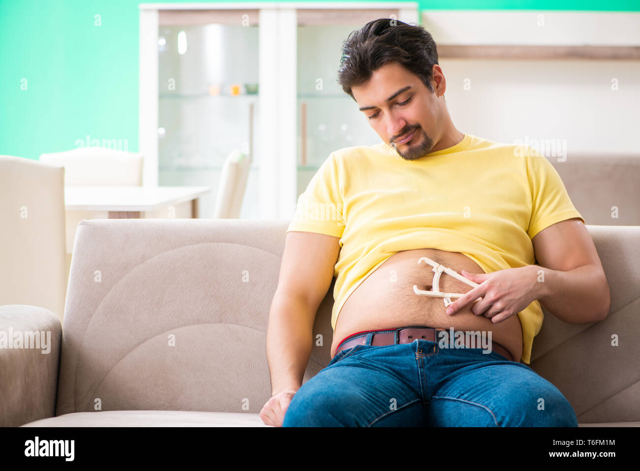 Young man measuring body fat with calipers Stock Photo - Alamy
