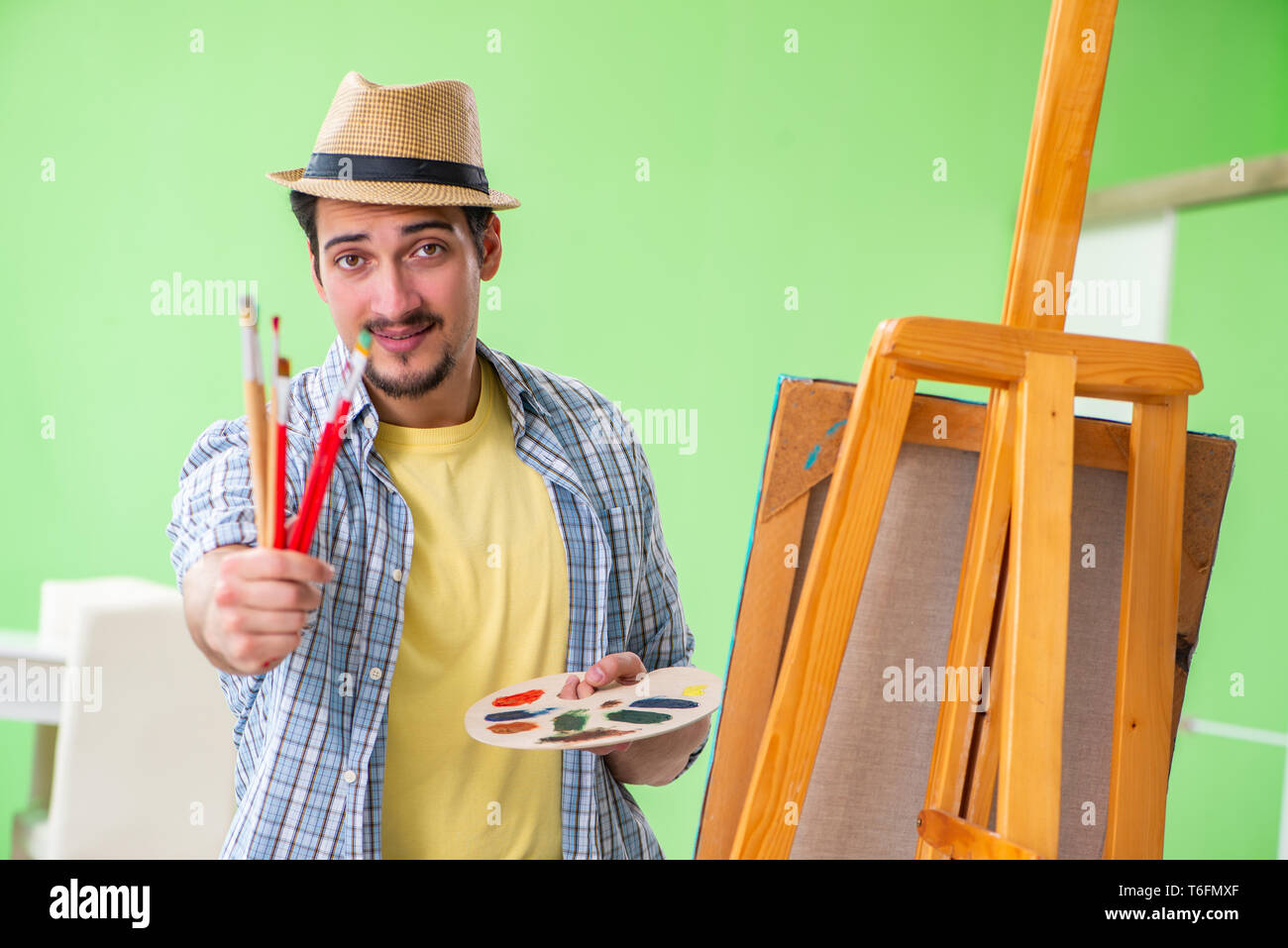 Young male artist working on new painting in his studio Stock Photo - Alamy