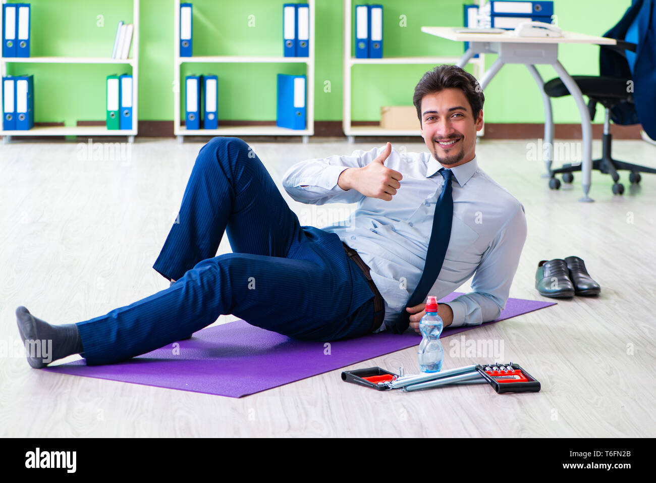 Employee doing exercises during break at work Stock Photo - Alamy