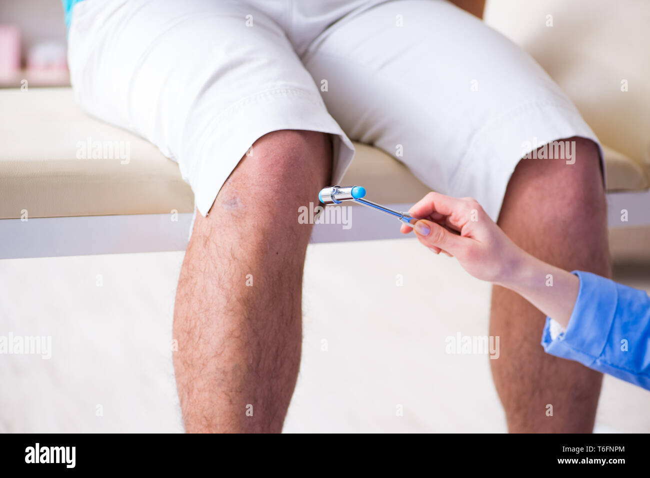 Doctor checking nerve reflexes with hammer Stock Photo - Alamy