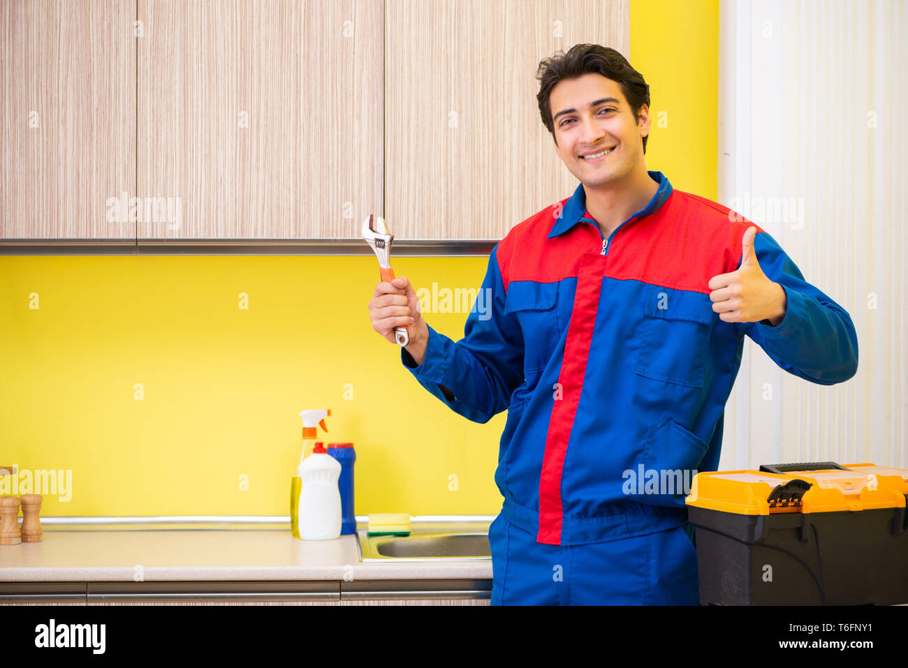 Plumber repairing tap at kitchen Stock Photo - Alamy