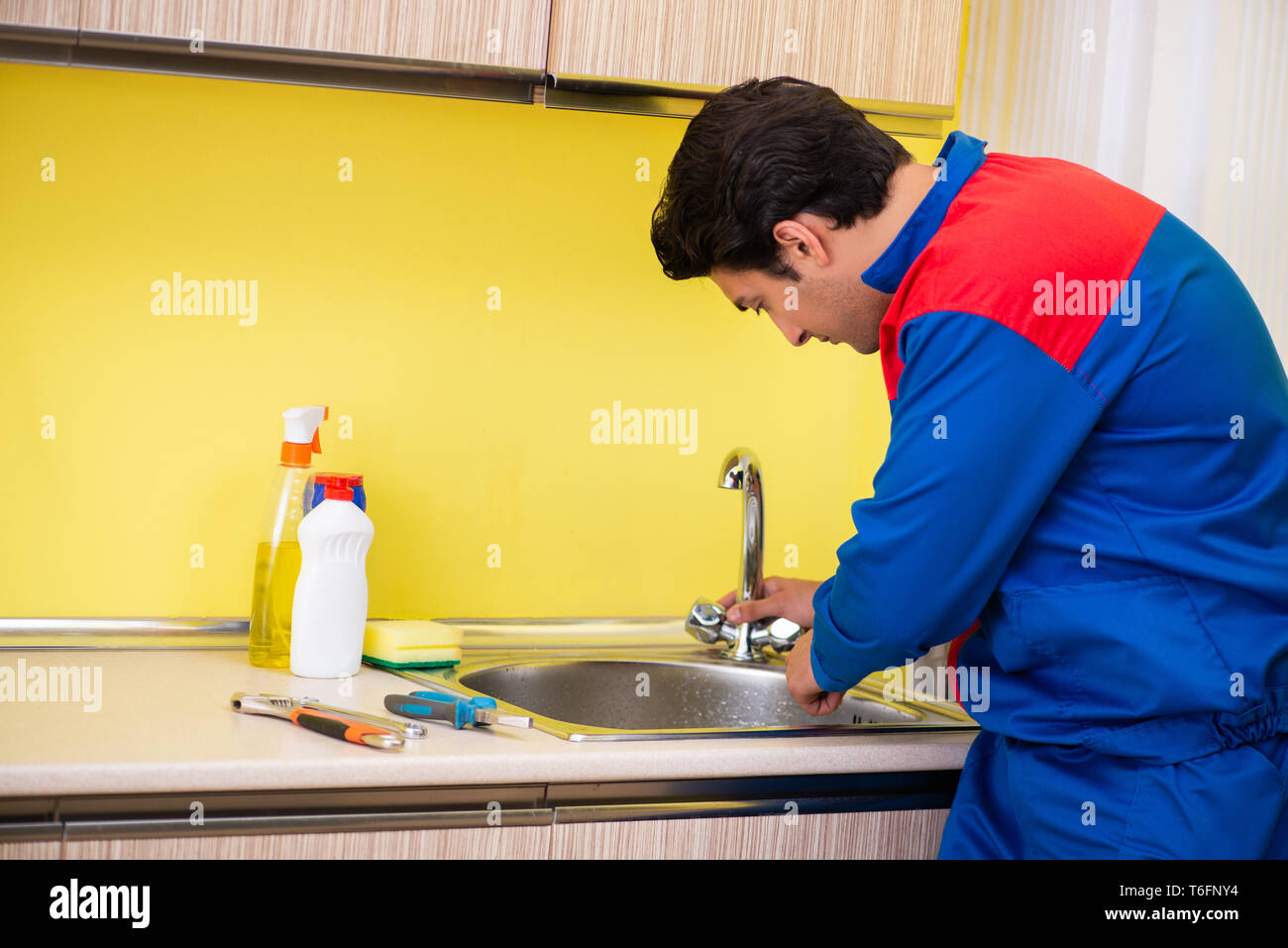 Plumber repairing tap at kitchen Stock Photo - Alamy