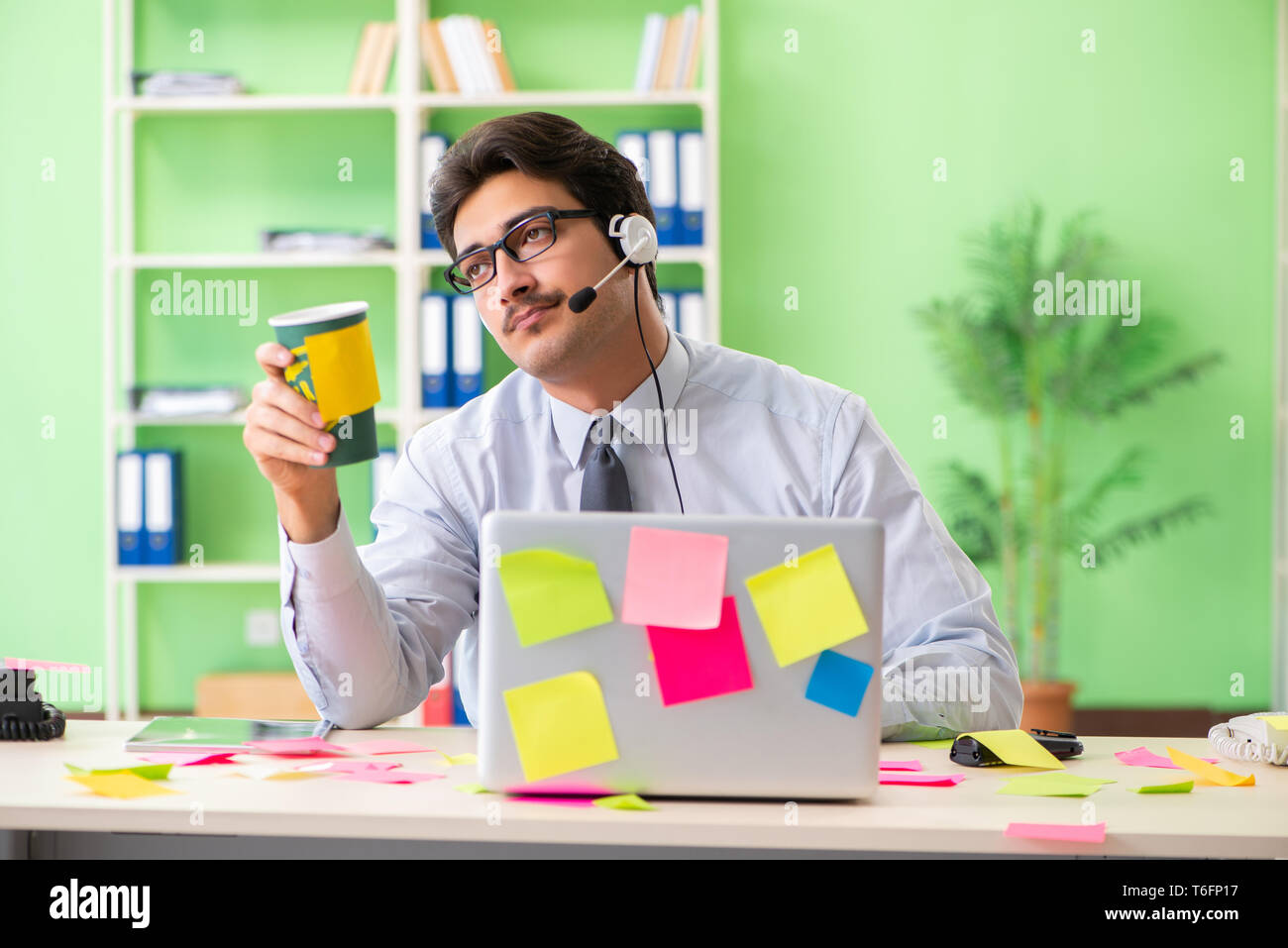 Young help desk operator working in office with many conflicting Stock ...