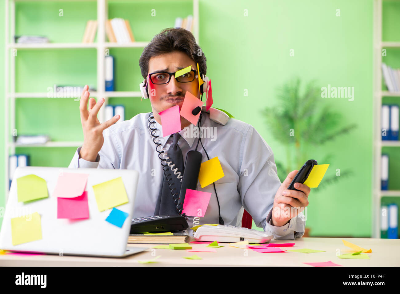 Young help desk operator working in office with many conflicting Stock ...