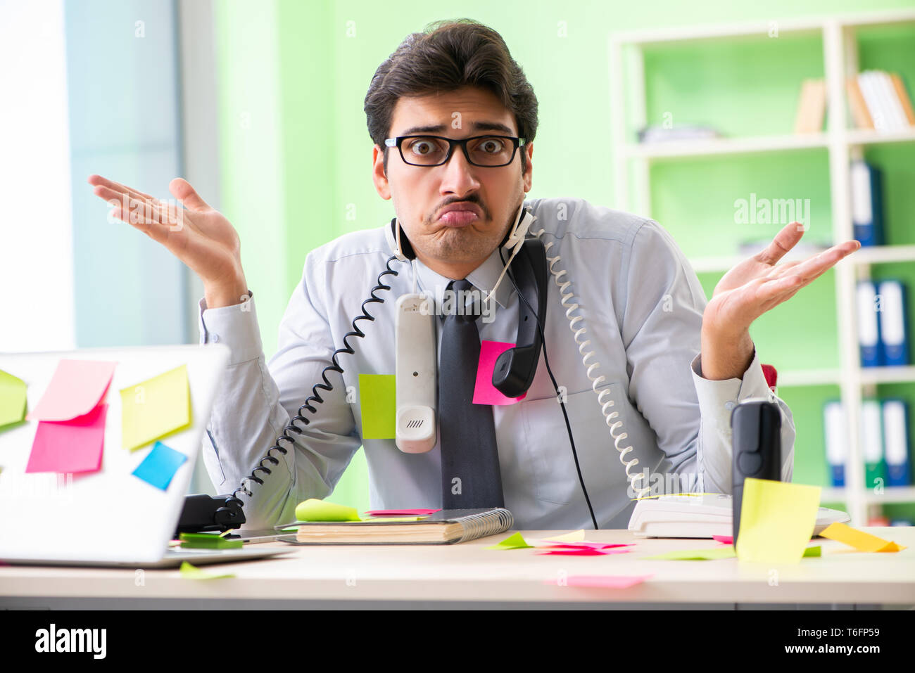 Young help desk operator working in office with many conflicting Stock ...