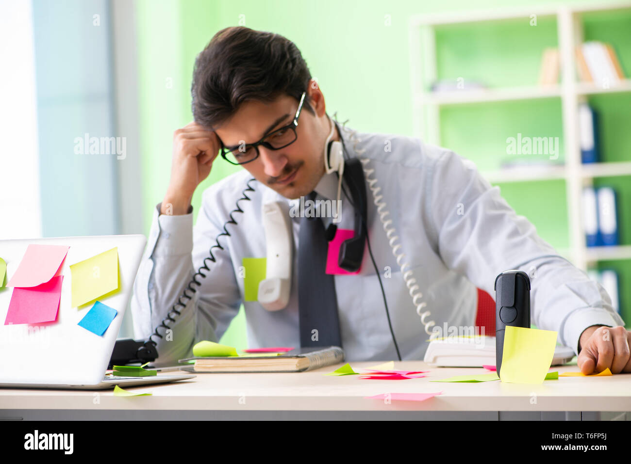 Young help desk operator working in office with many conflicting Stock ...