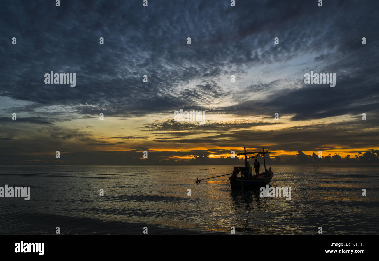 A beautiful tropical dawn with a fishing boat Stock Photo - Alamy