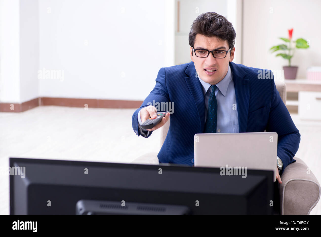 Businessman watching tv in the office Stock Photo - Alamy