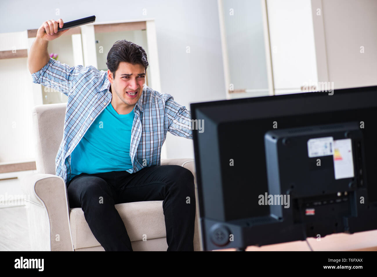 Man watching tv at home Stock Photo - Alamy