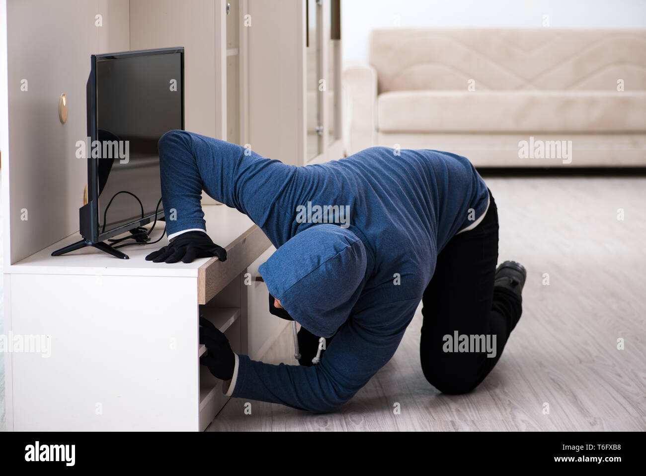 Man burglar stealing tv set from house Stock Photo - Alamy