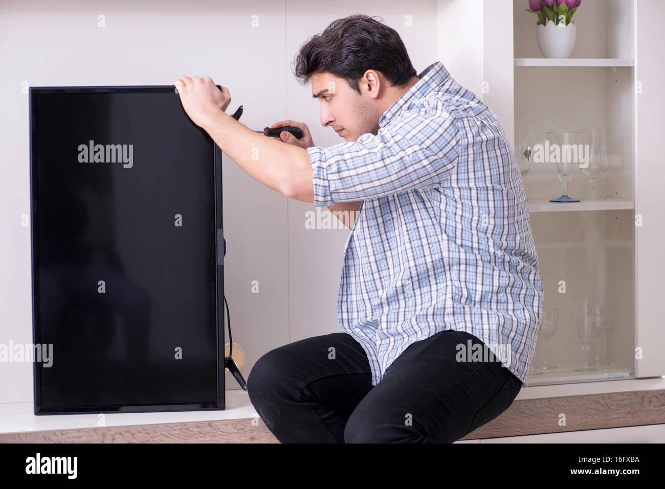 Man repairing broken tv at home Stock Photo - Alamy