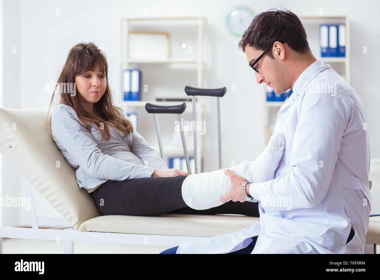 Doctor examining patient with broken leg Stock Photo - Alamy