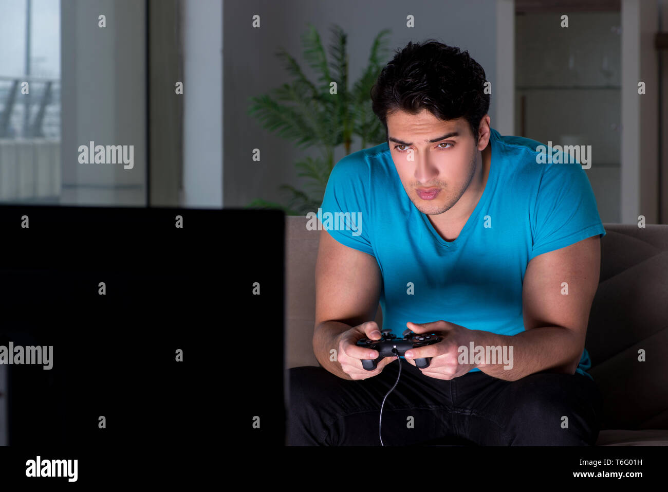 Young man playing computer games late at night Stock Photo - Alamy