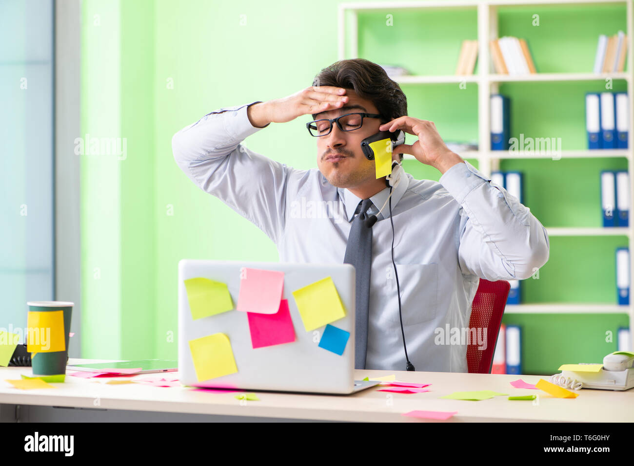 Young help desk operator working in office with many conflicting Stock ...
